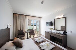 Quarto Superior, vista parcial para o mar | Minibar, ferro/tábua de engomar, Wi-fi grátis, roupa de cama fornecida 