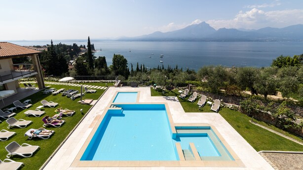 Piscina com vista para o mar e montanhas.