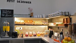 Um buffet de café da manhã com diversos alimentos e bebidas.