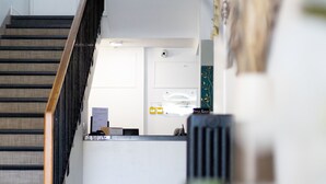 Um interior moderno com escadas, um balcão de recepção e um radiador.
