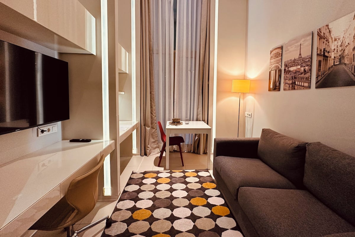 Quarto casal standard, 1 cama King | Área de estar | Smart TV 35 polegadas com canais via satélite