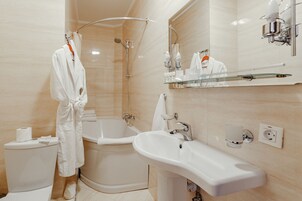 Uma casa de banho moderna com banheira, lavatório e cabine de chuveiro em vidro.