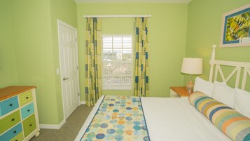 Quarto com cama, mesa de cabeceira, cômoda e janela com cortinas.