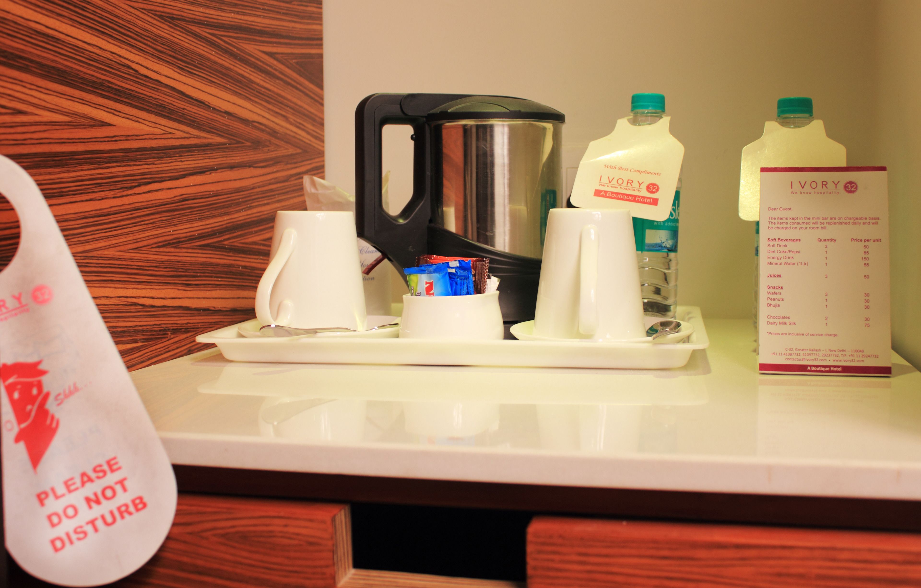 Disposição para o pequeno-almoço num quarto de hotel, incluindo máquina de café, leite em embalagens individuais e um menu.