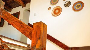 Uma escada de madeira com corrimão que leva a um patamar.
