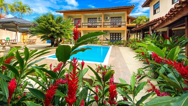 Um hotel com piscina, área de estar externa e vegetação exuberante.