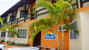 Um edifício com uma placa que diz 'Malibu Porto Hotel'.