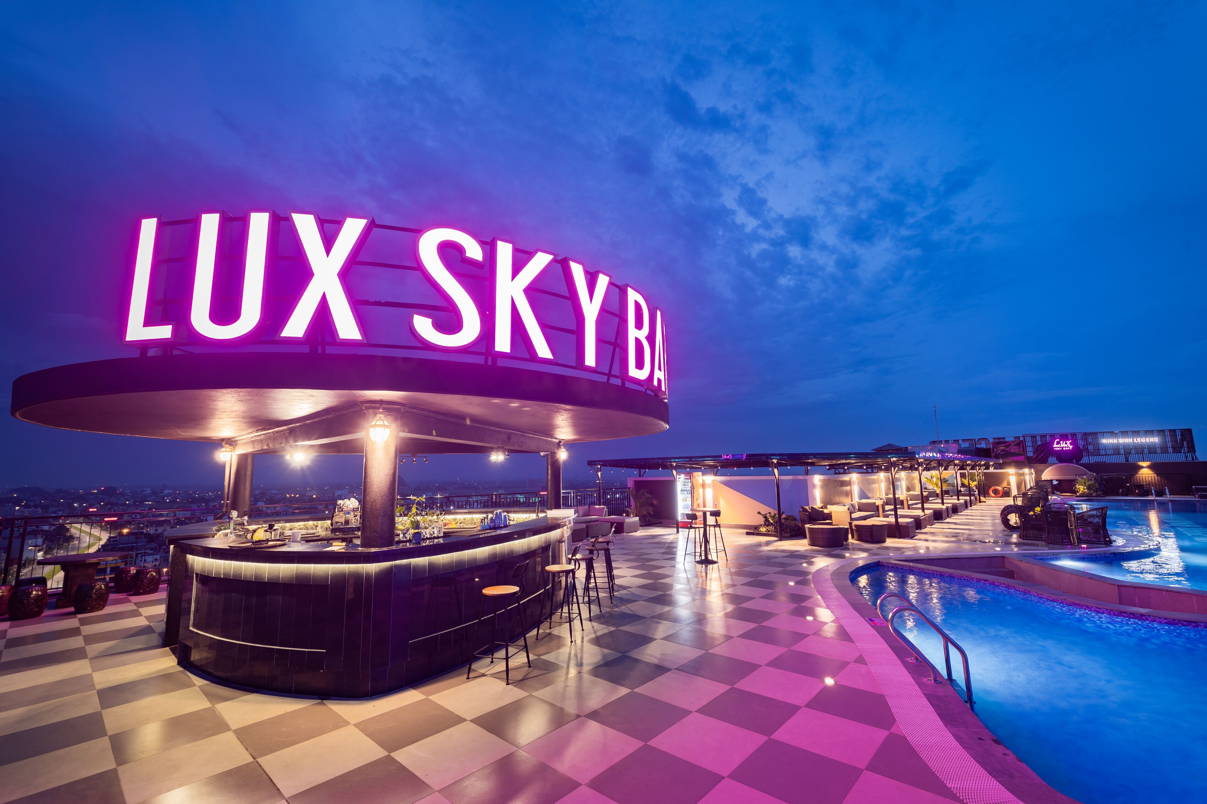 Um bar chamado "LUX SKYBAR", com chão xadrez e área de piscina.