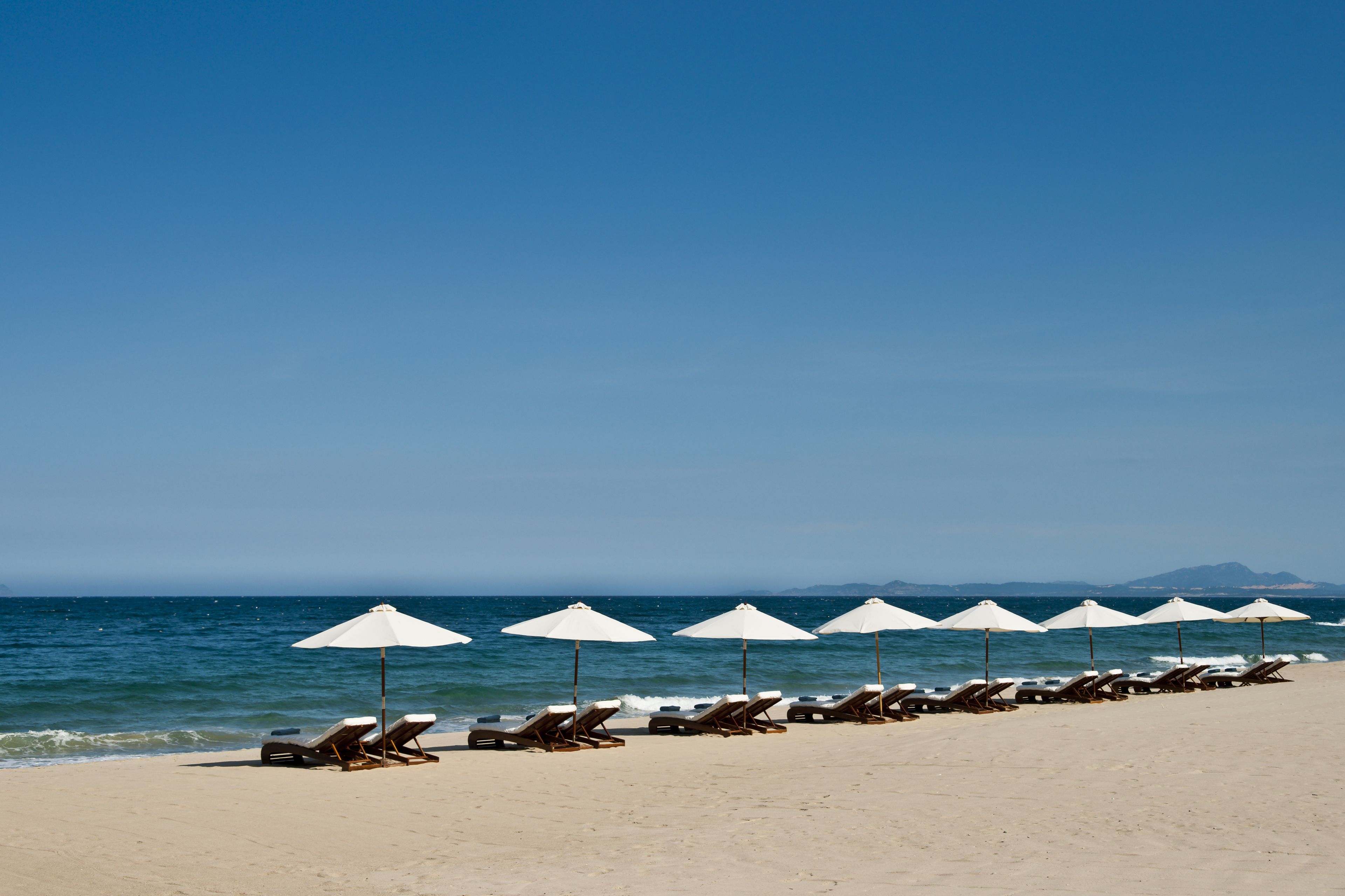 Praia particular, espreguiçadeiras, guarda-sóis, toalhas de praia 