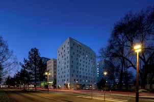 Um hotel de vários andares com design moderno, apresentando uma placa grande com a inscrição 'seven urban' no edifício.