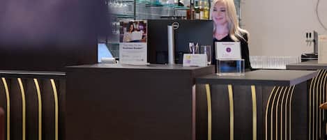 Uma receção com uma placa a indicar 'Premier Inn' e um recepcionista.