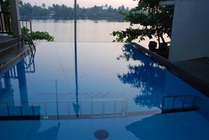 Piscina com vista para um corpo d'água e um barco ao longe.