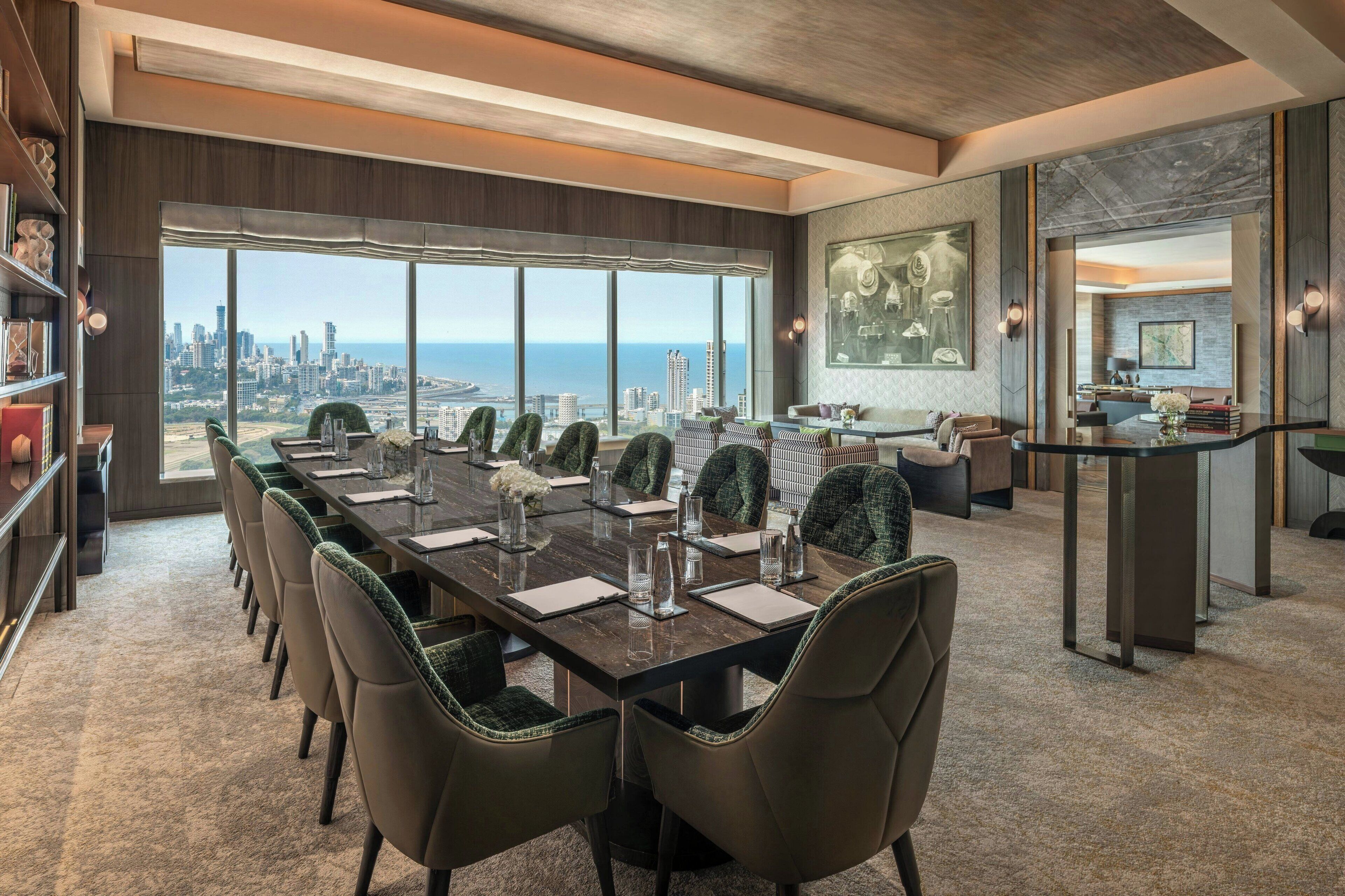 Uma sala de conferências com uma mesa comprida, cadeiras e vista para a cidade.