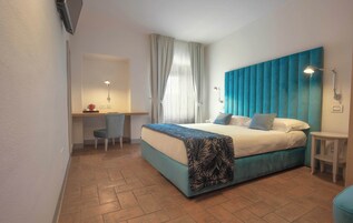Quarto com cama, escrivaninha e cadeira.