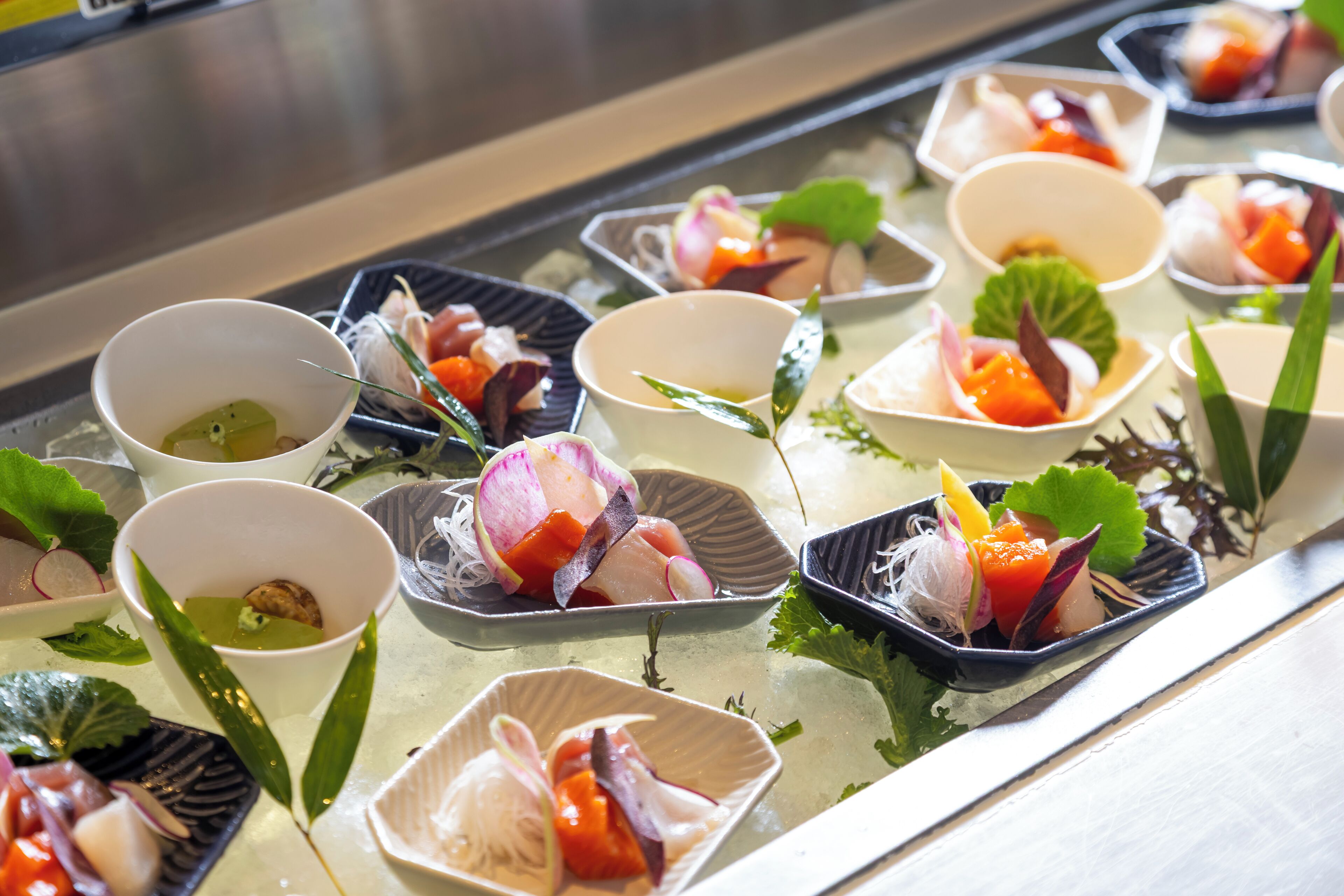 Diversos tipos de sushi dispostos numa bandeja.