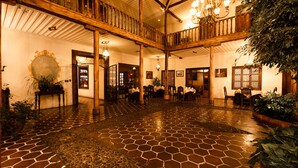 Um hall amplo com teto alto, varanda de madeira e piso ladrilhado.