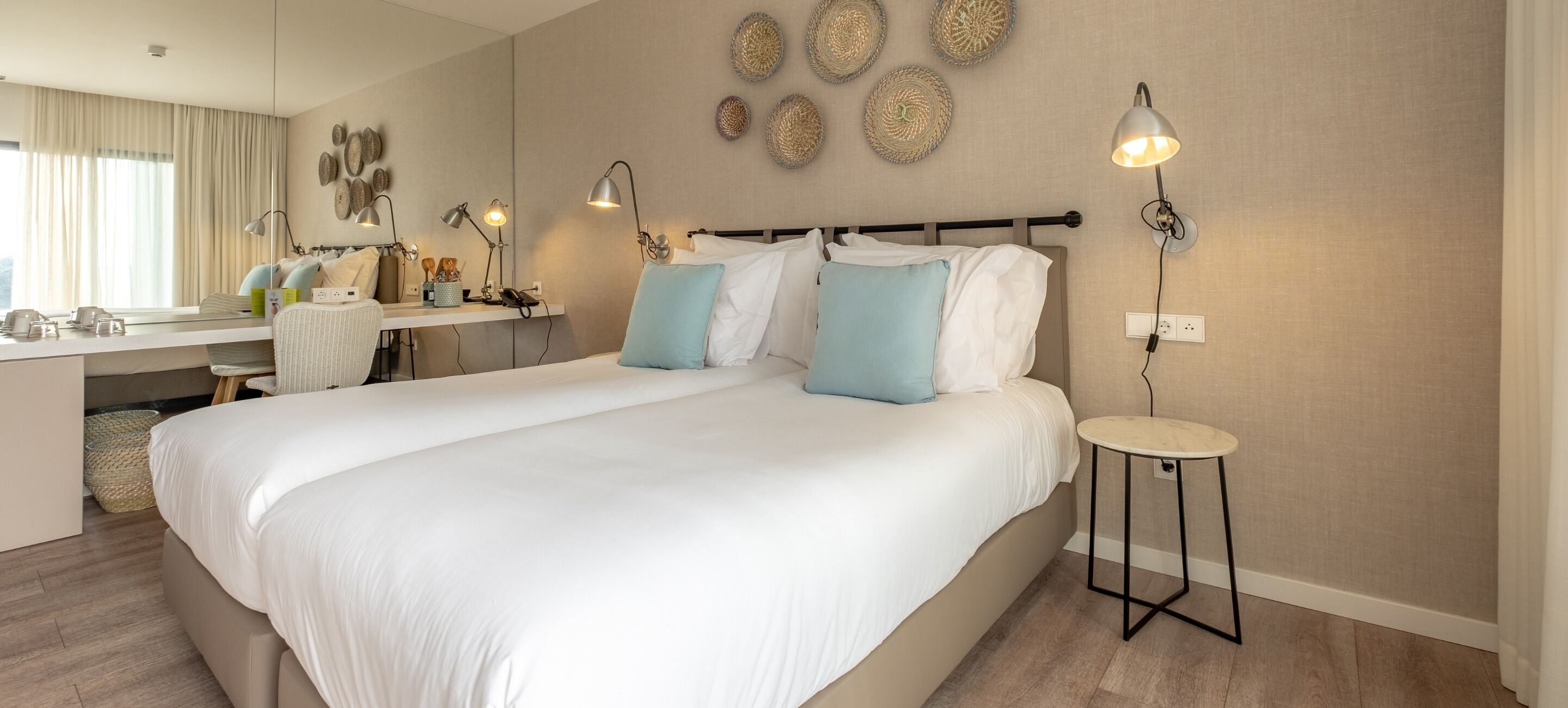Quarto de hotel moderno com uma cama grande, uma escrivaninha e uma cadeira.