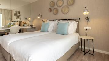 Quarto de hotel moderno com uma cama grande, uma escrivaninha e uma cadeira.