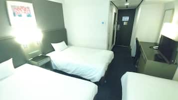 Quarto de hotel com duas camas, uma escrivaninha, uma cadeira, uma televisão e uma janela pequena.