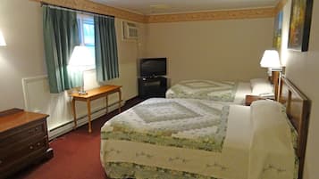Quarto de hotel com duas camas, televisão, secretária e cómoda.
