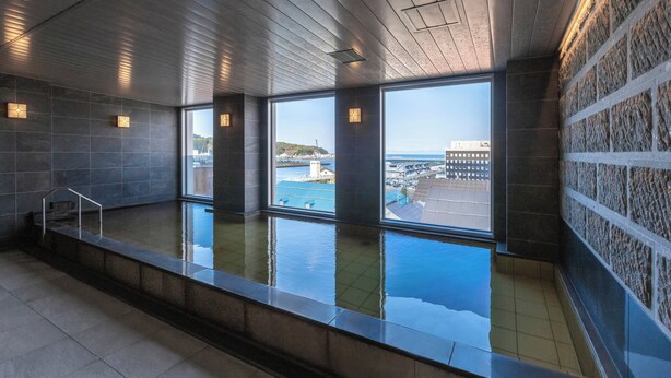 Área interna de piscina moderna com vista para uma ponte e edifícios.