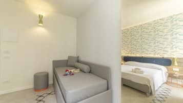 Quarto moderno com cama-sofá, cama de casal e papel de parede estampado, além de uma mesinha de cabeceira.