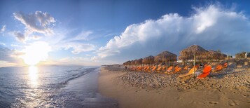 Na praia, espreguiçadeiras, guarda-sóis de praia 