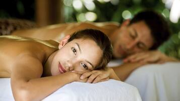 Um casal deitado em uma cama em um ambiente de spa.
