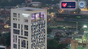 Um hotel moderno com muitos andares, design contemporâneo, várias varandas e uma placa chamativa.
