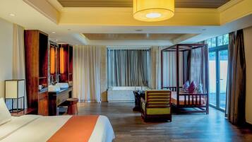 Quarto de hotel com uma cama grande, área de estar com uma cadeira, escrivaninha com abajur, janela com cortinas e luminária no teto.