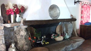 Uma lareira de pedra com objetos decorativos, incluindo vasos e uma cesta.