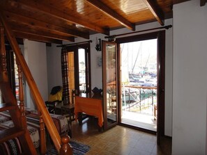 Interior de madeira com varanda com vista para uma marina.