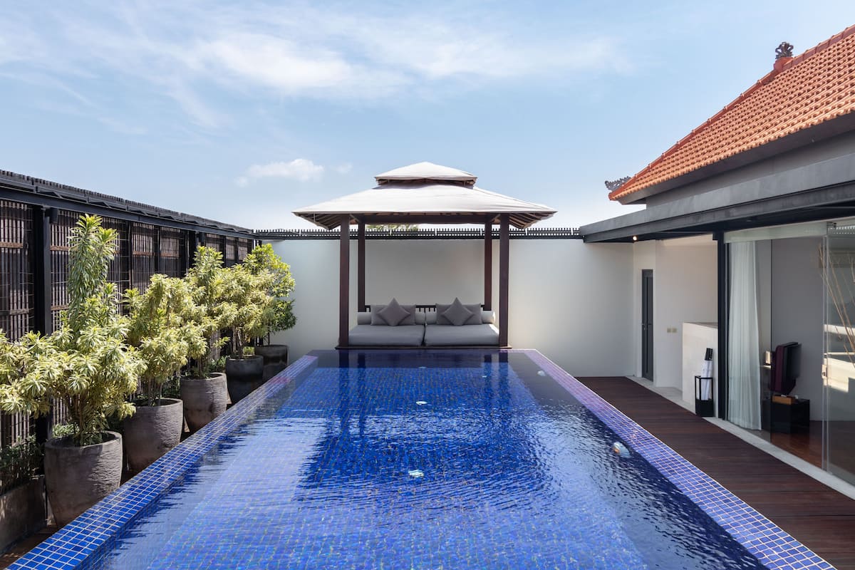 Uma piscina moderna ao ar livre, com pérgola e área de estar.