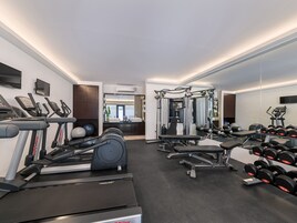Uma academia moderna com equipamentos de cardio, máquinas de peso e halteres.