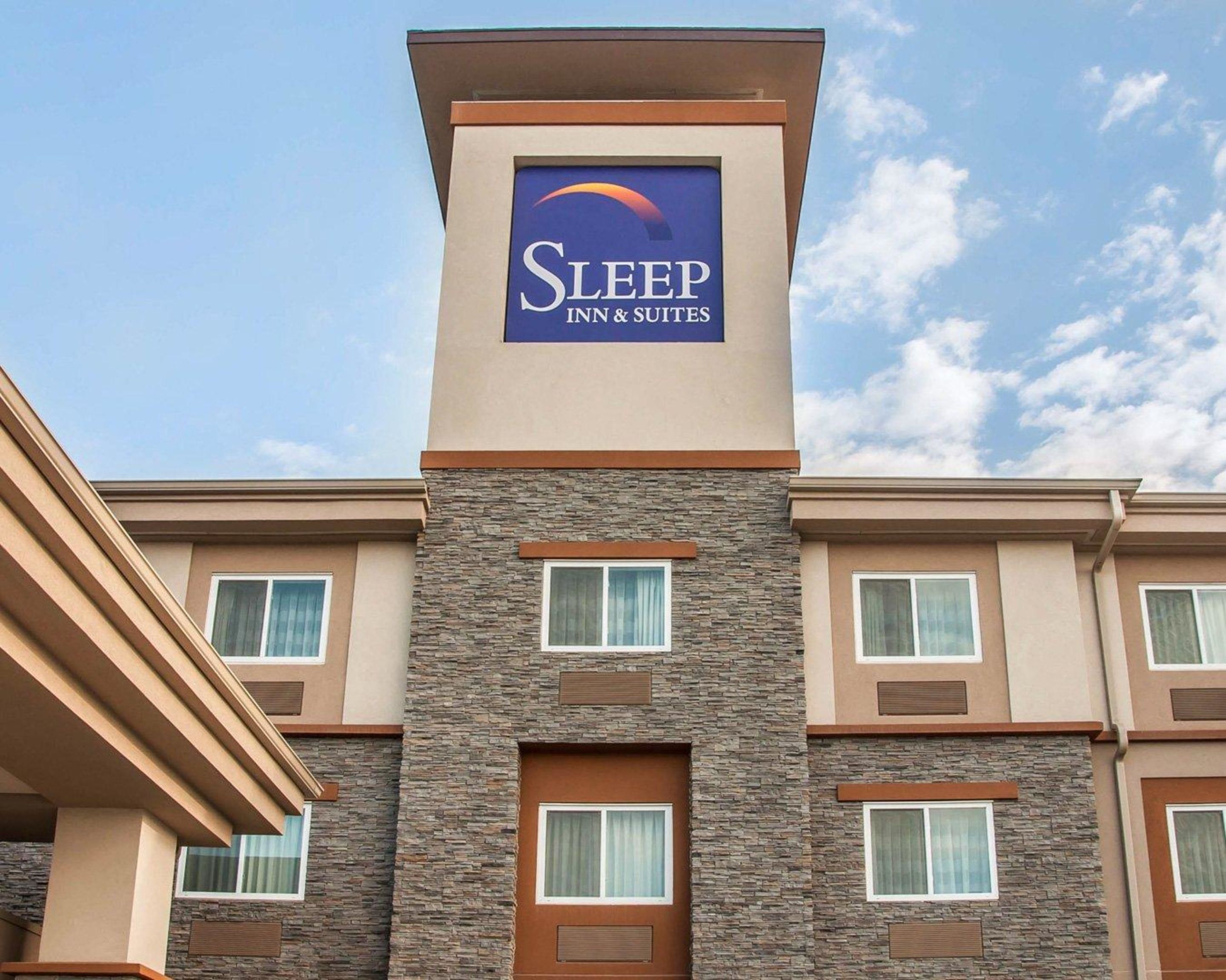 Um hotel Sleep Inn & Suites com fachada de pedra e várias janelas.