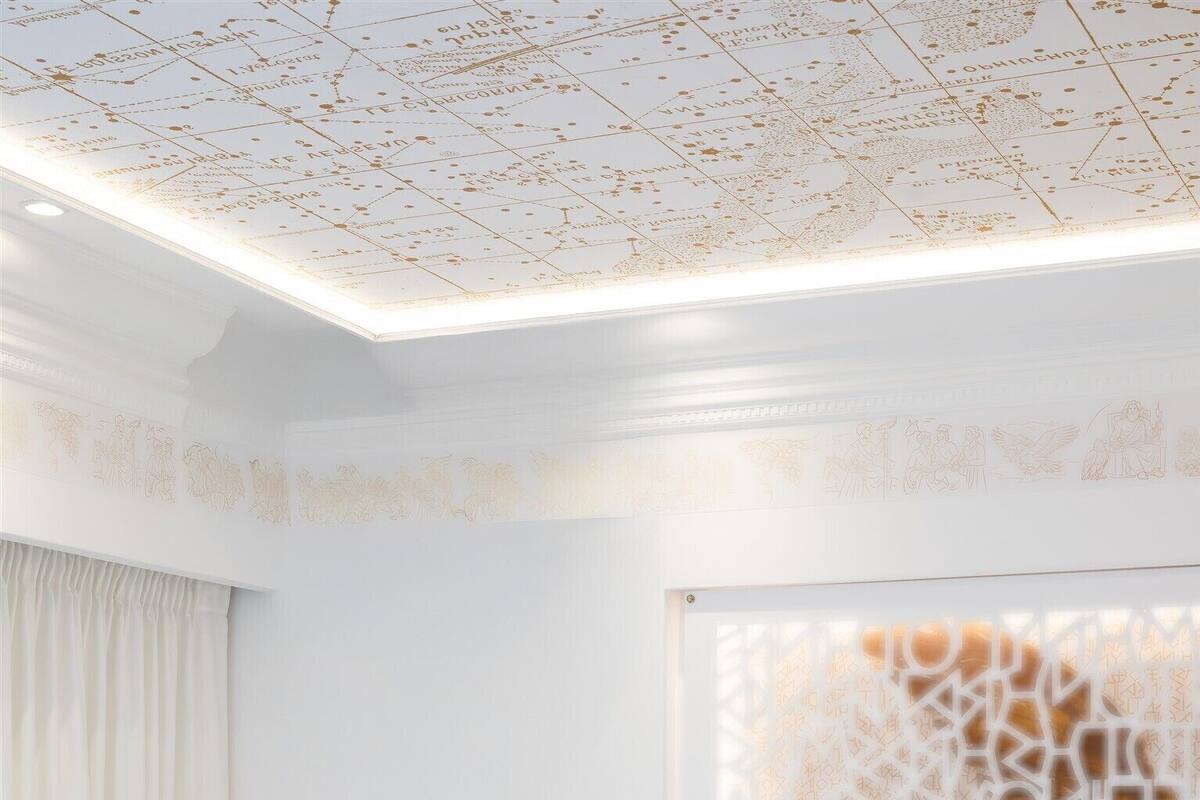 Quarto de hotel com cama, uma cadeira, uma mesinha e um ecrã decorativo.