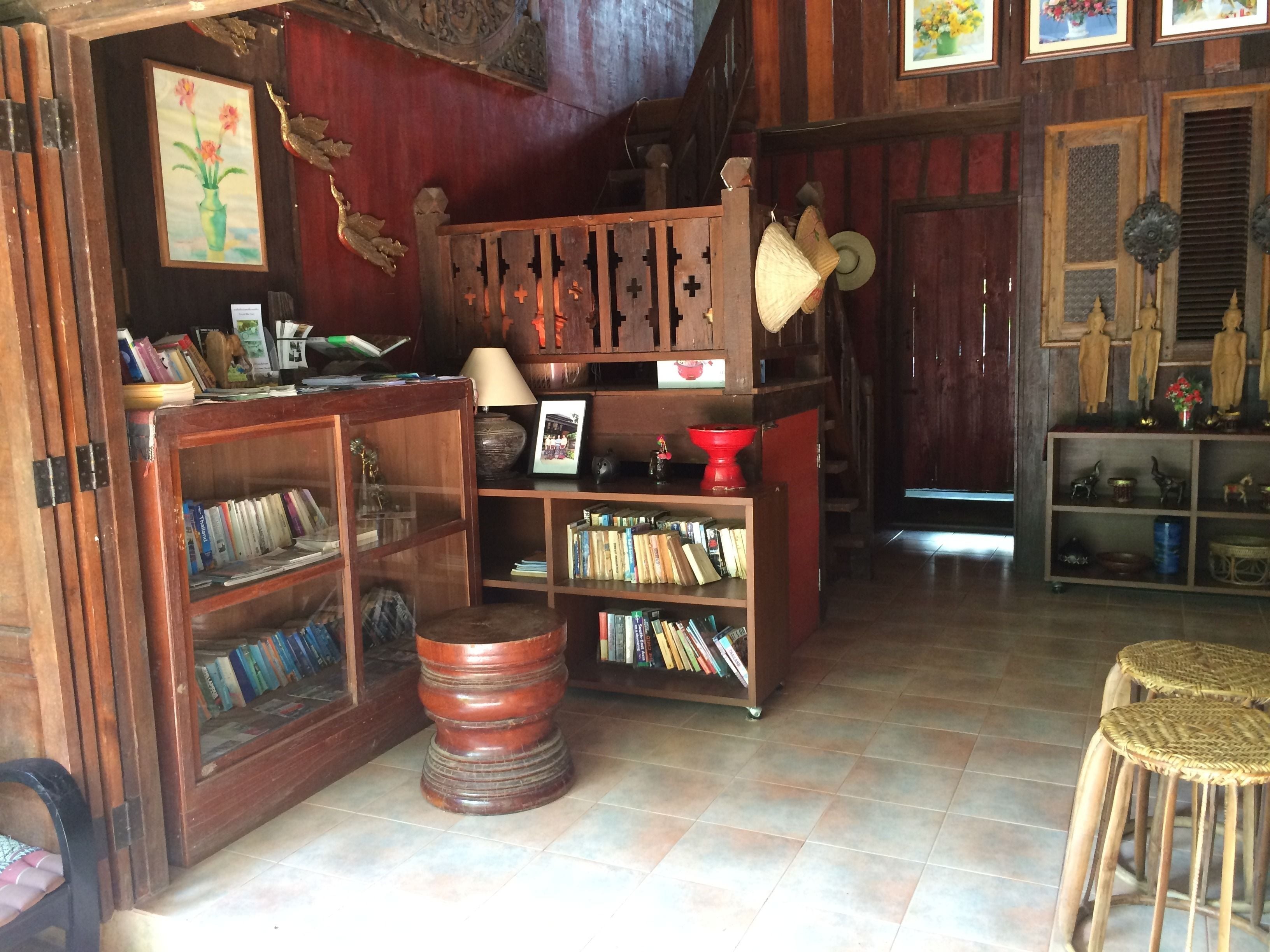 Quarto de madeira tradicional com estantes, um banquinho de madeira e um banquinho trançado.