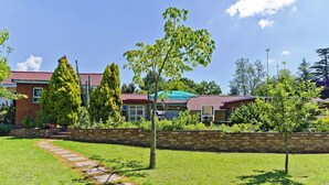 Um bairro residencial com uma casa de tijolos, um caminho e um gramado bem cuidado.