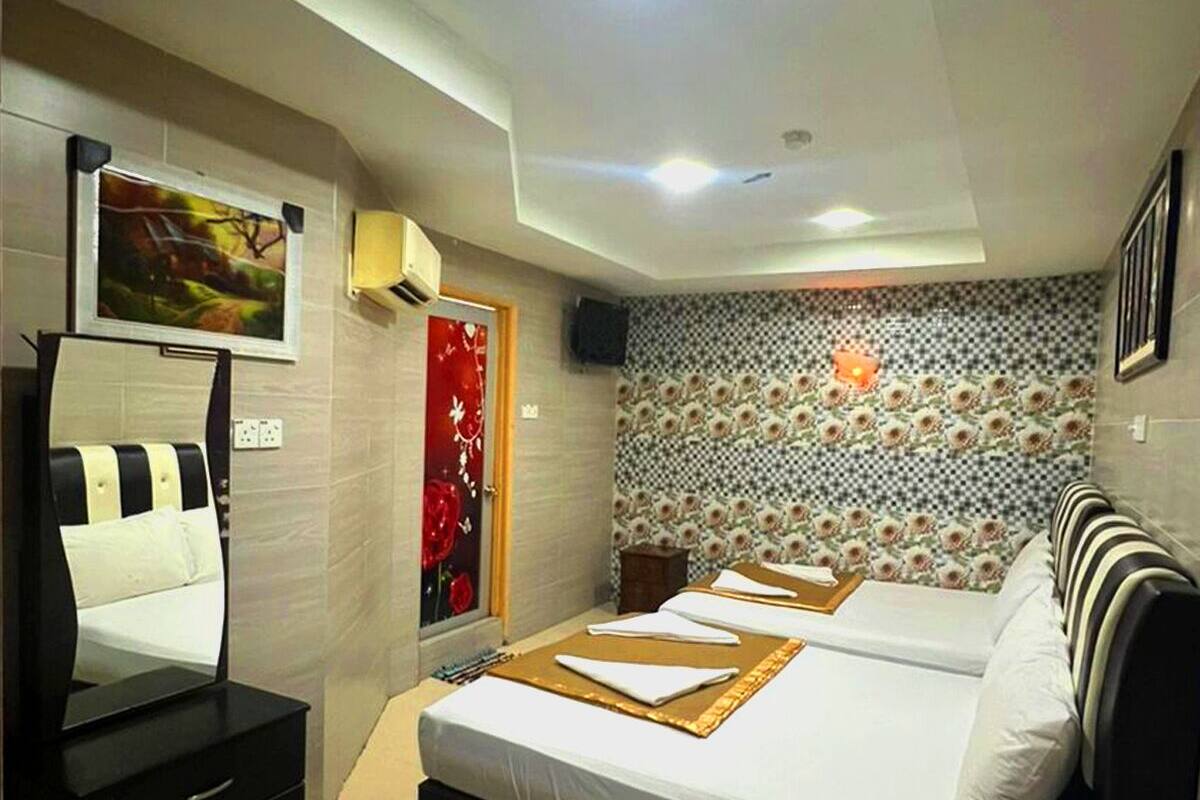 Quarto moderno com cama, mesas de cabeceira, um espelho e detalhes decorativos na parede.
