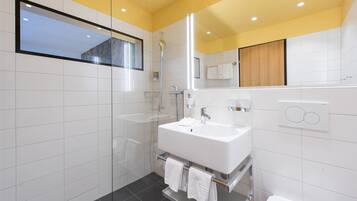 Um polibã e uma banheira separados, um secador de cabelo