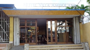 Entrada de hotel com uma placa que diz "HOTEL VILLA AMERICANA".