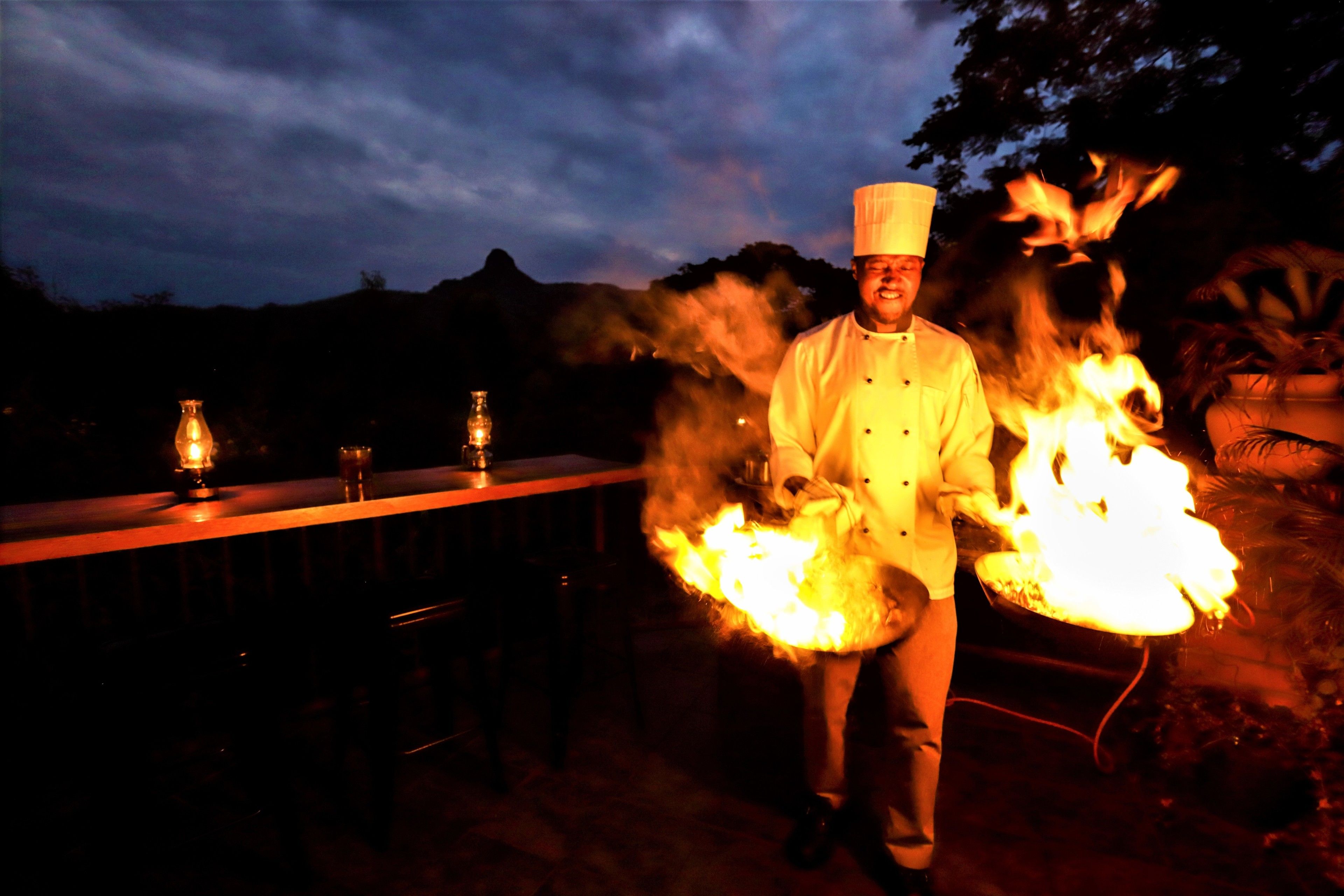 Um chefe de cozinha demonstra suas habilidades com fogo.
