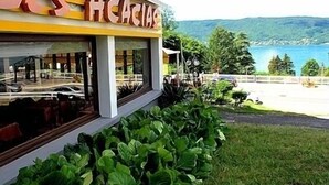 Um restaurante com vista para um lago e montanhas.