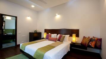 Quarto bem arrumado com uma cama grande, abajures e mesa de cabeceira.