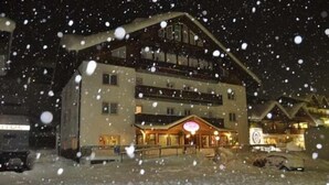 Um edifício de vários andares com um restaurante no andar térreo, rodeado de neve.