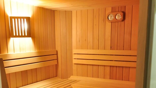 Uma sauna com bancos de madeira e teto inclinado.