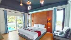 Quarto amplo com uma cama grande, uma cadeira e vista para uma piscina.