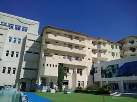 Um edifício de vários andares com piscina, área externa coberta e estrutura moderna em vidro.