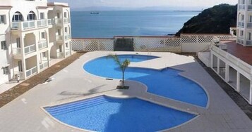 Uma piscina no terraço com vista para o mar.