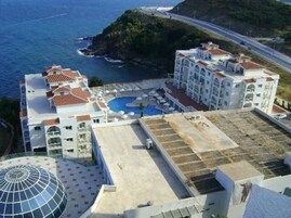 Um hotel à beira-mar com vários edifícios, piscina e uma estrutura em cúpula.